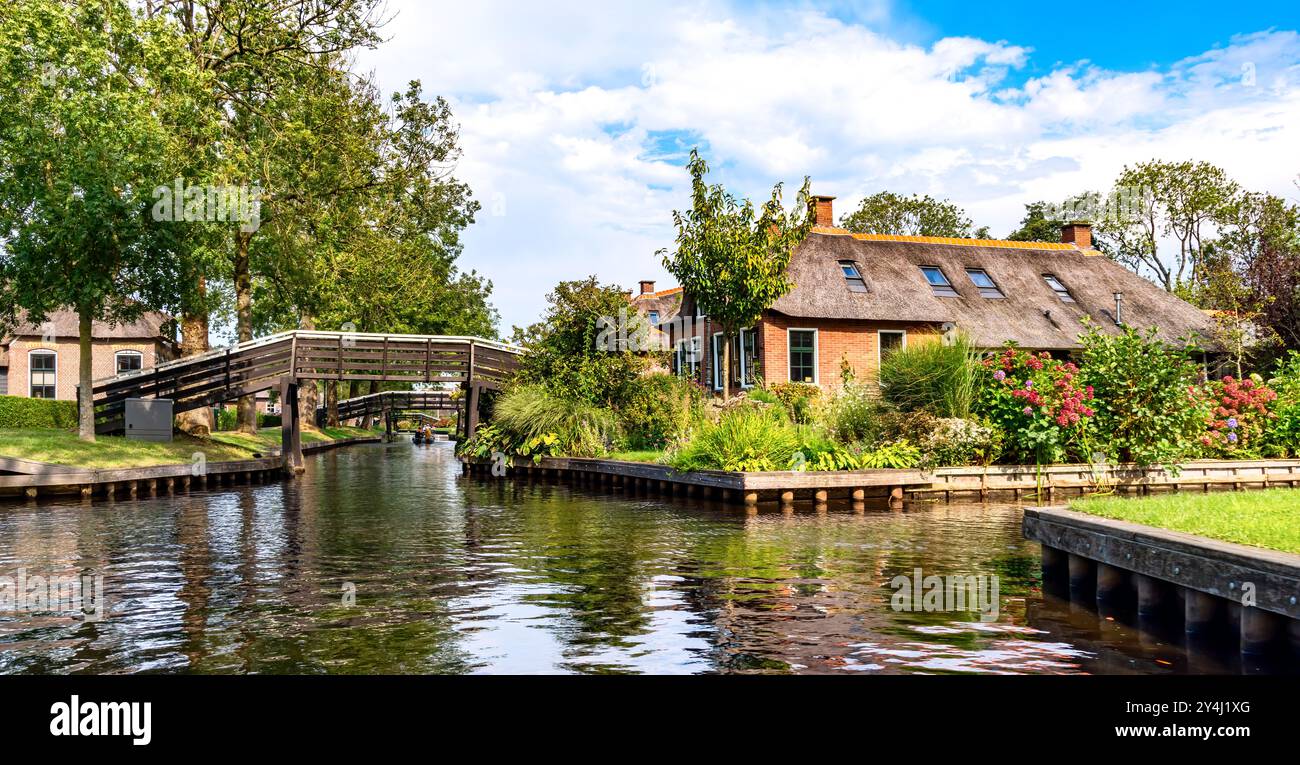 A tranquil riverside village with thatched-roof cottages and boats ...