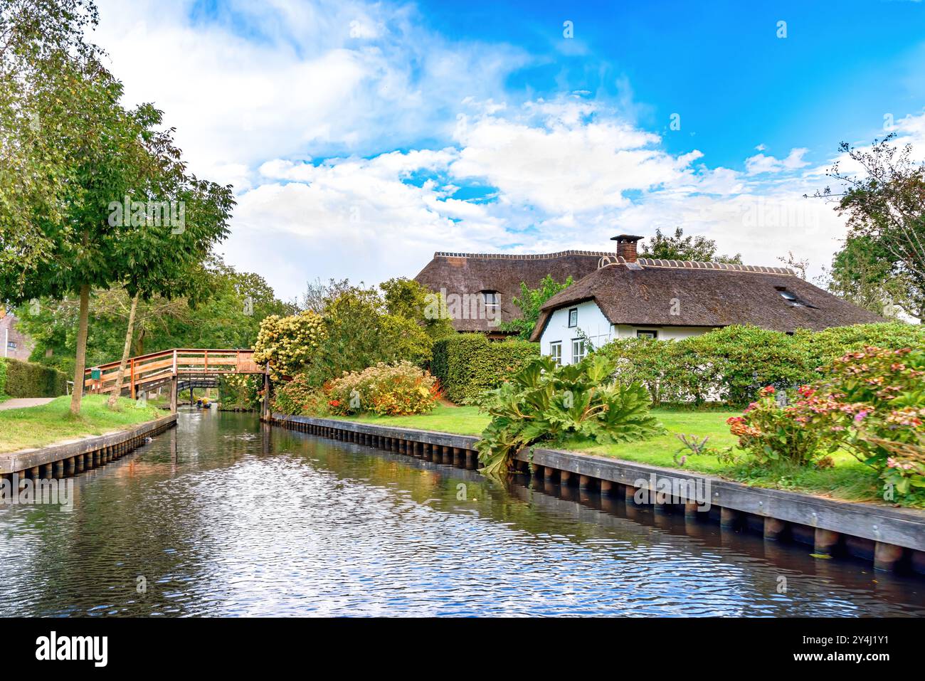 Traditional Dutch thatched-roof cottages on the canal in the village of ...