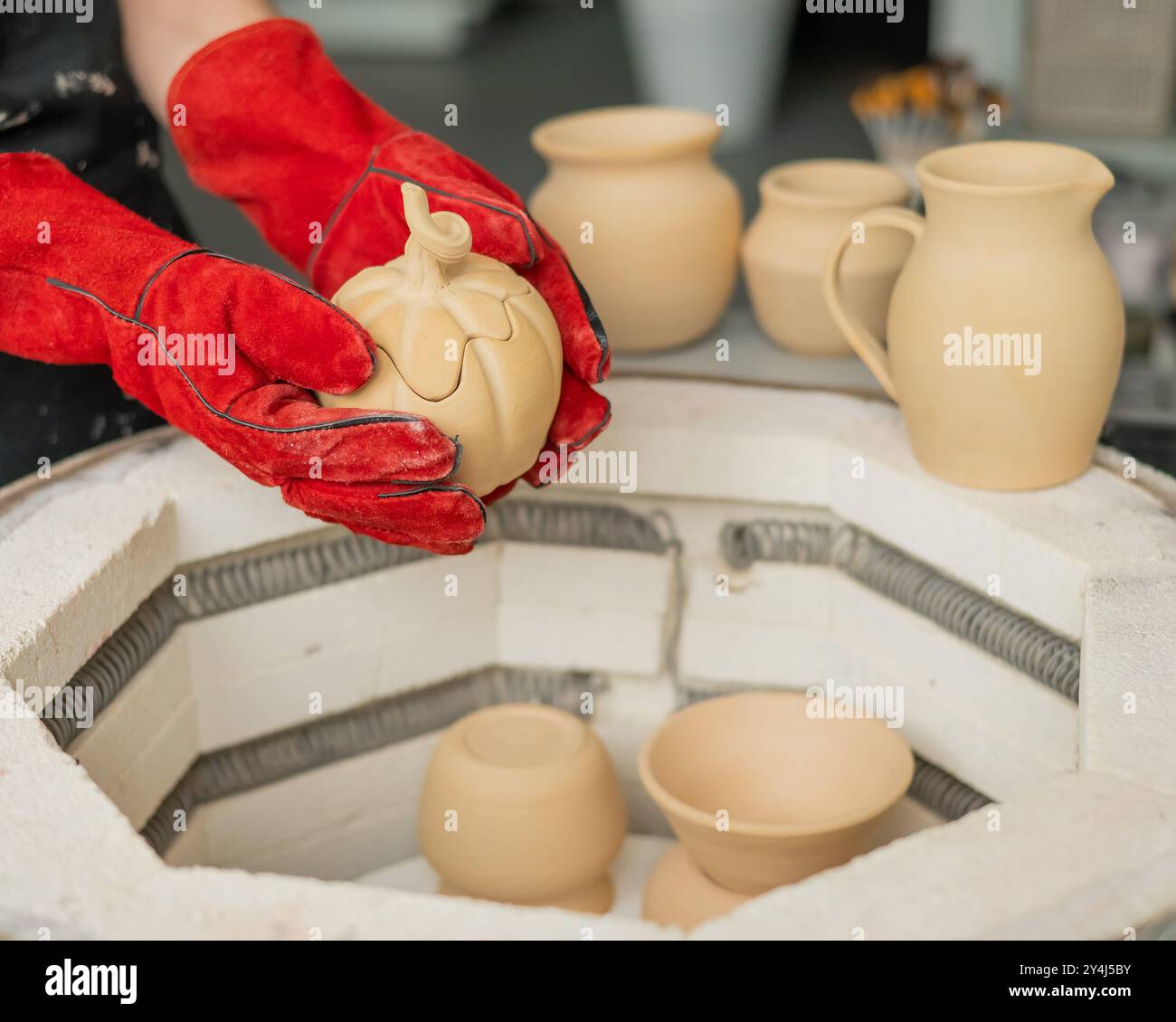 Close-up of a man's hands loading ceramics into a special kiln Stock ...