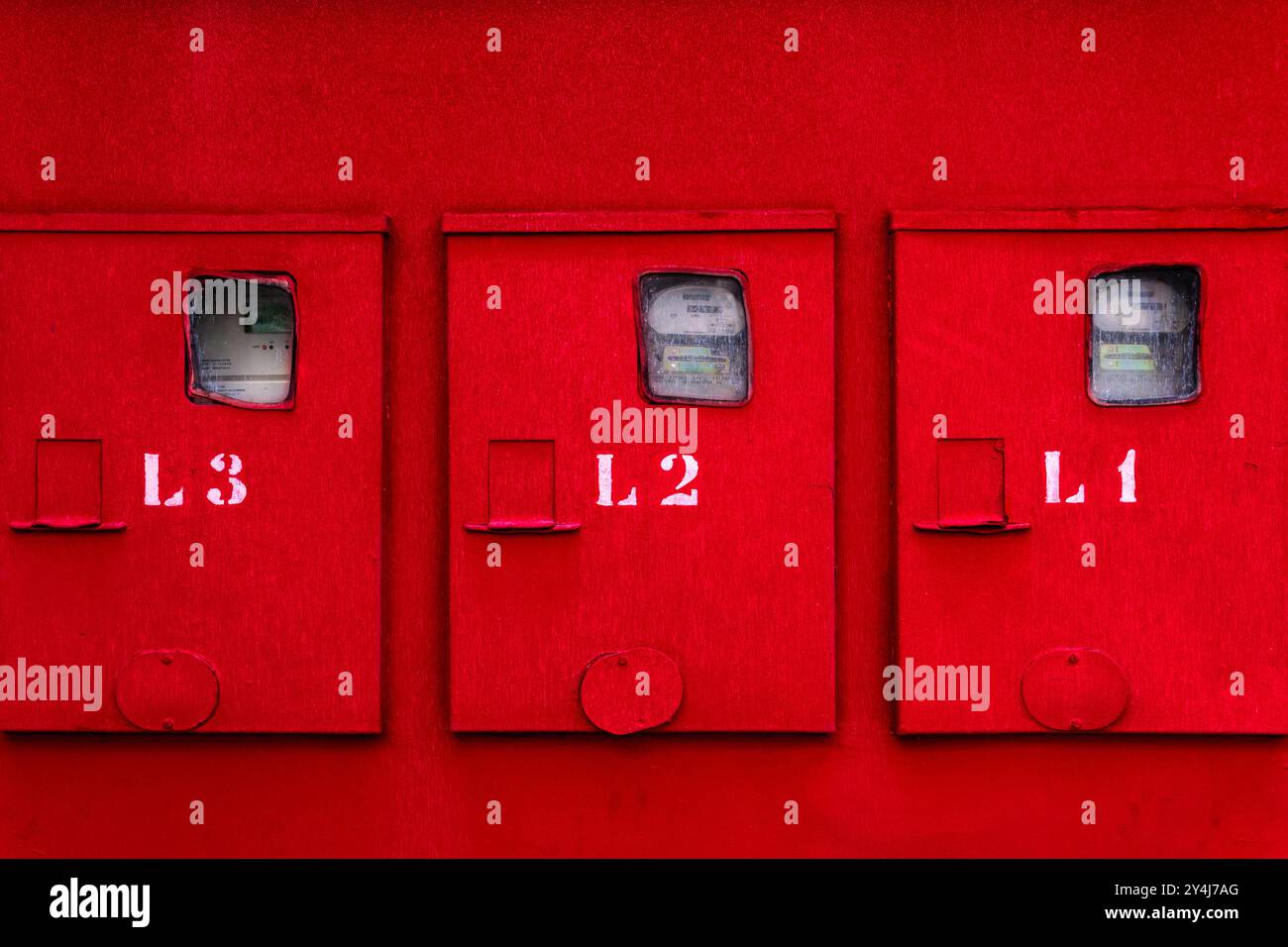 Red wall with with three Brazilian numbered meter boxes in Belo ...