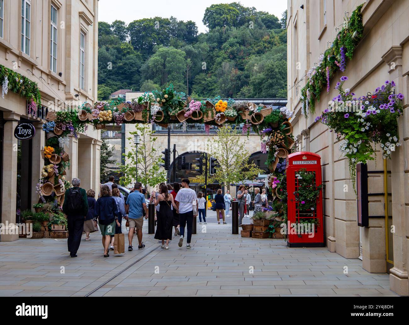A charming pedestrian street adorned with hanging flower baskets ...