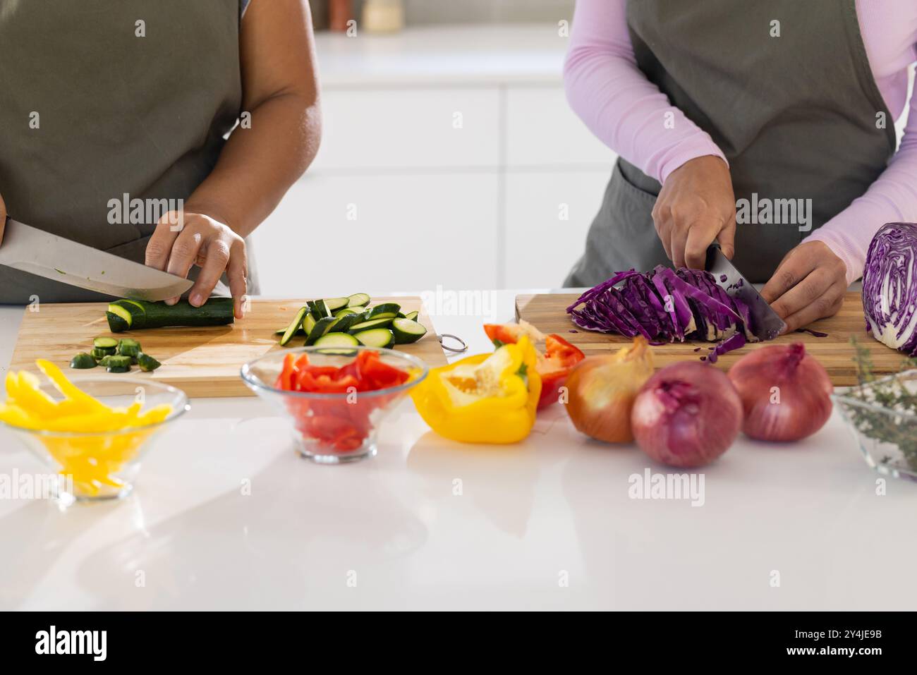 Chopping vegetables, two people preparing fresh ingredients in kitchen ...