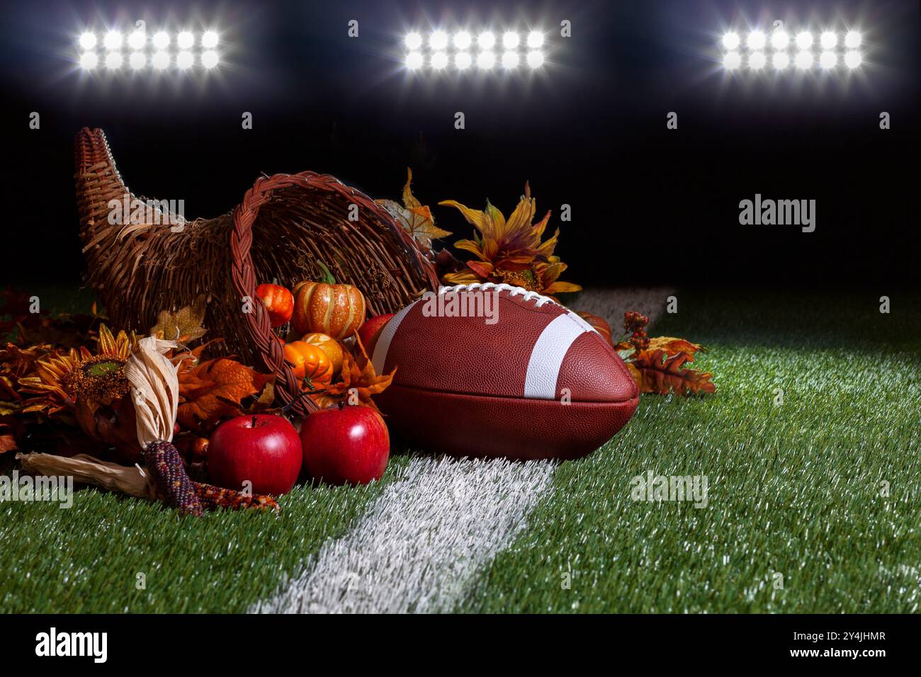 A cornucopia with a football on a grass field with stripe and dark ...