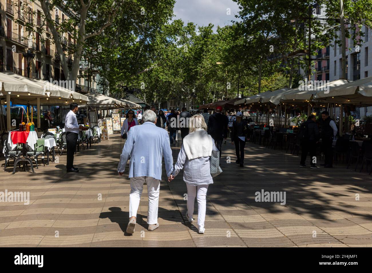 People stroll along La Rambla, one of Barcelona, Spain's most famous ...