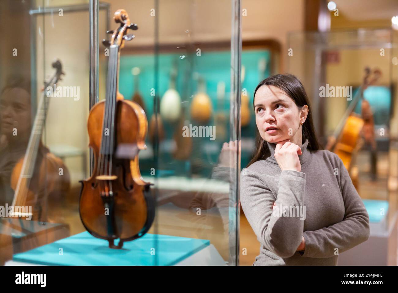 Female museum visitor examining ancient musical instruments Stock Photo ...