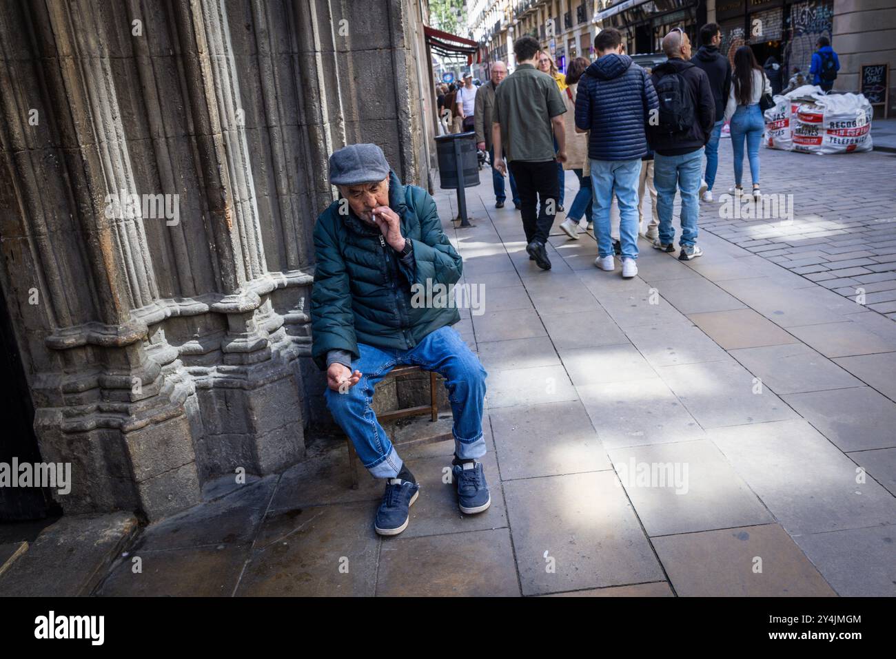 An elderly man sitting outside a church in Barcelona, Spain asking for ...