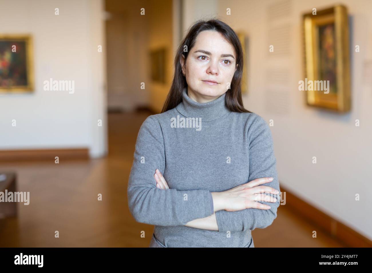 Interested woman visiting exhibition of paintings in art museum Stock ...