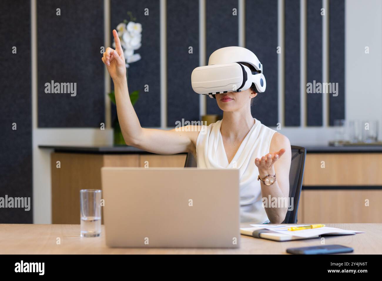 Using VR headset, businesswoman interacting with virtual interface in office meeting Stock Photo ...