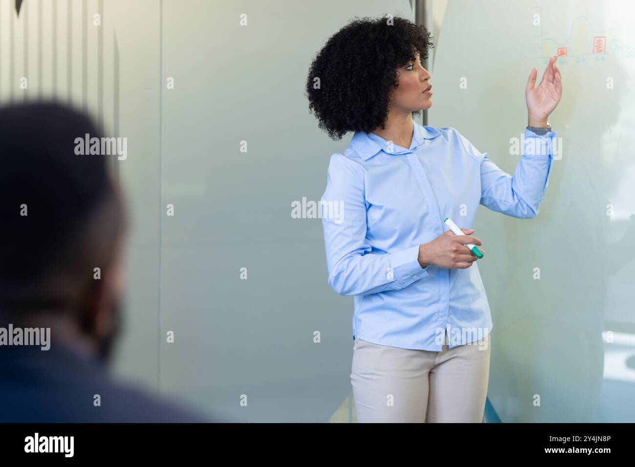 Presenting data on whiteboard, businesswoman explaining graph in ...