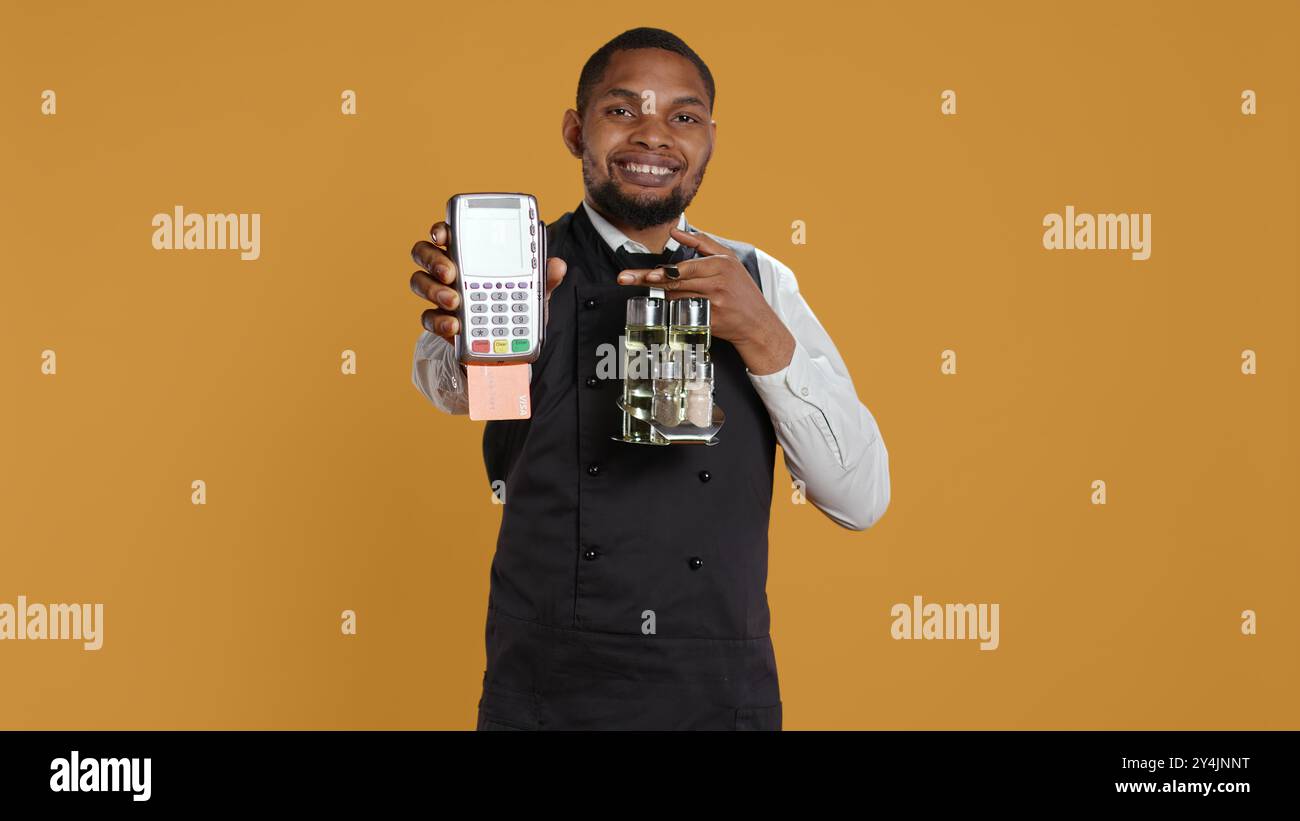 Skilled restaurant employee waiter presenting electronic payment method ...