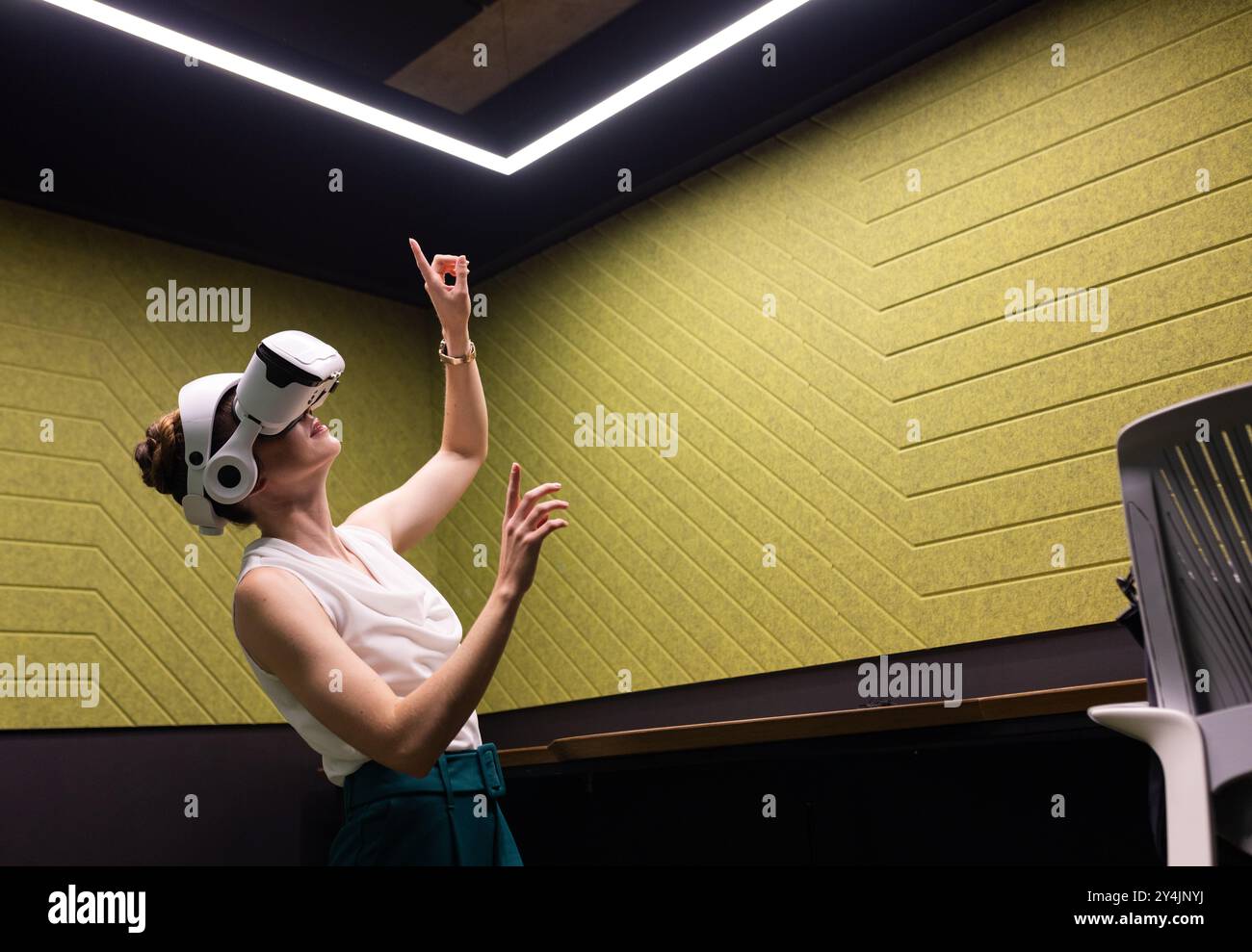 Using VR headset, woman interacting with virtual environment in modern office, copy space Stock ...