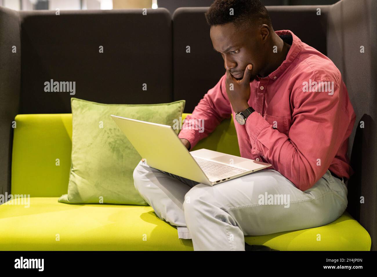 Working from home, african american man using laptop and concentrating ...