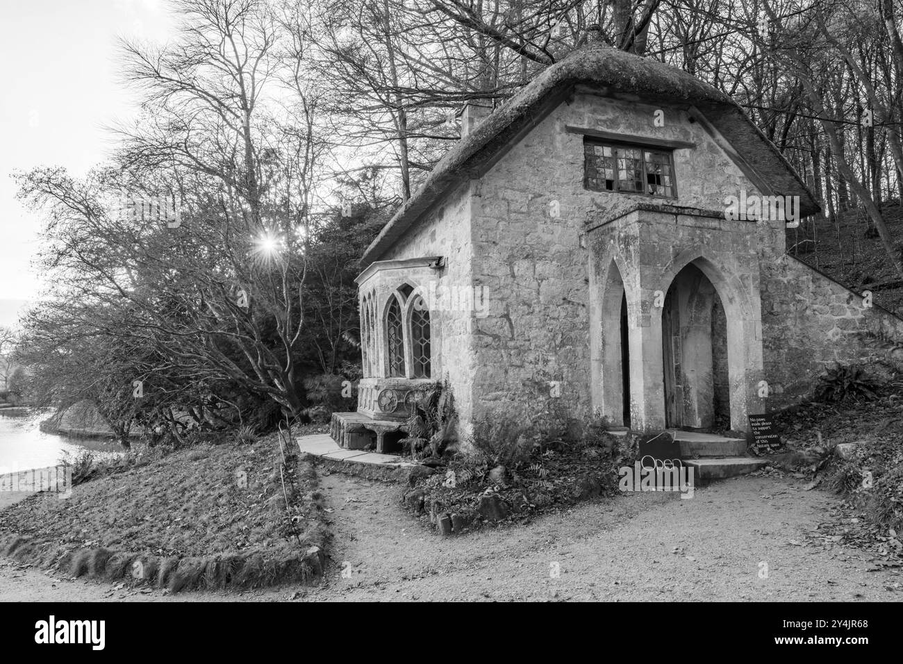 Black and white photo of the sun setting behind the Gothic Cottage at ...