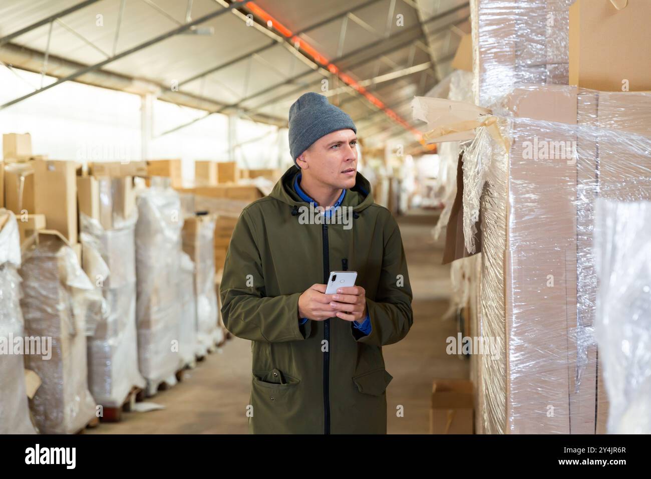 Store warehouse employee scans barcode on boxes using phone Stock Photo ...