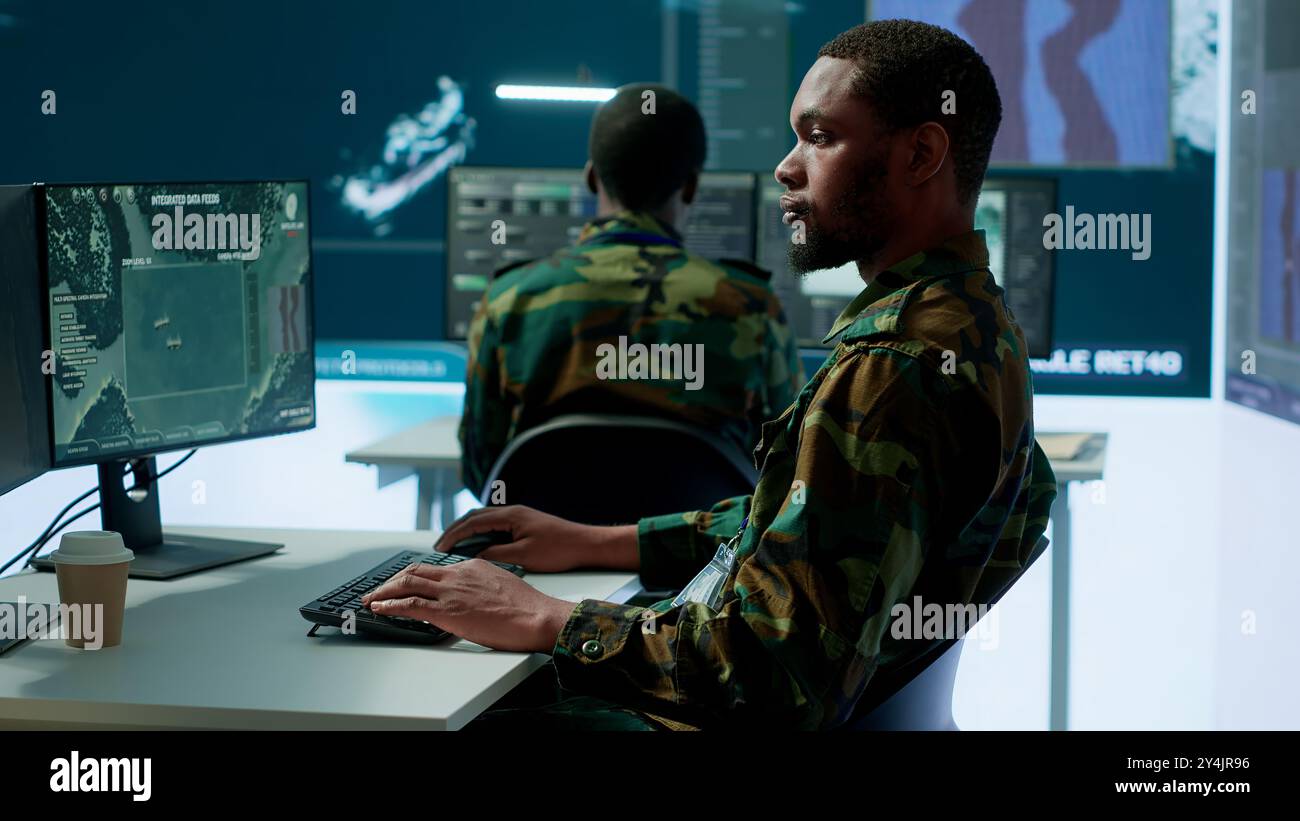 Military personnel in a high tech command center monitor satellite ...
