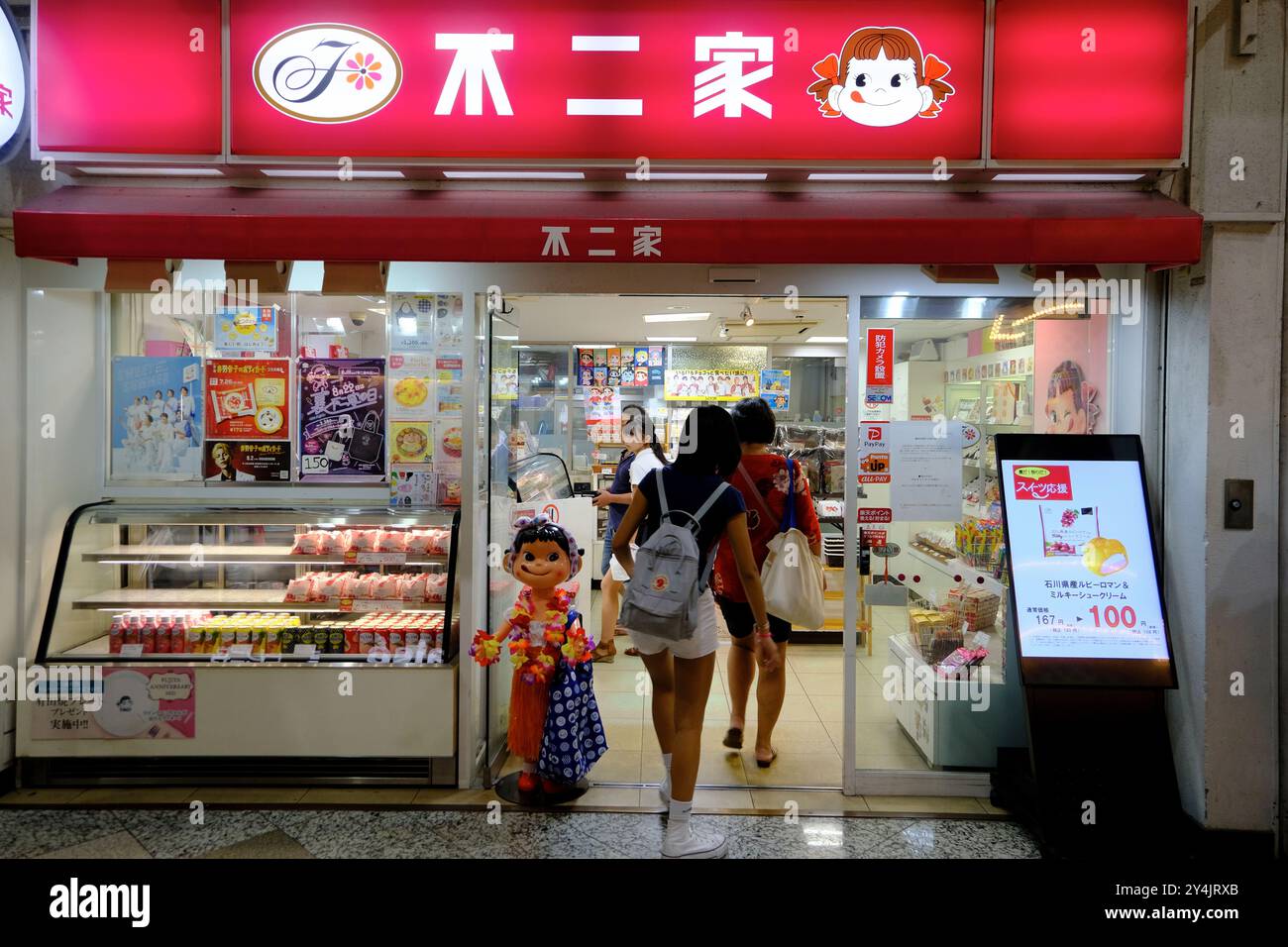 Customers entering Fujiya confectionery store with Fujiya's mascot Peko ...