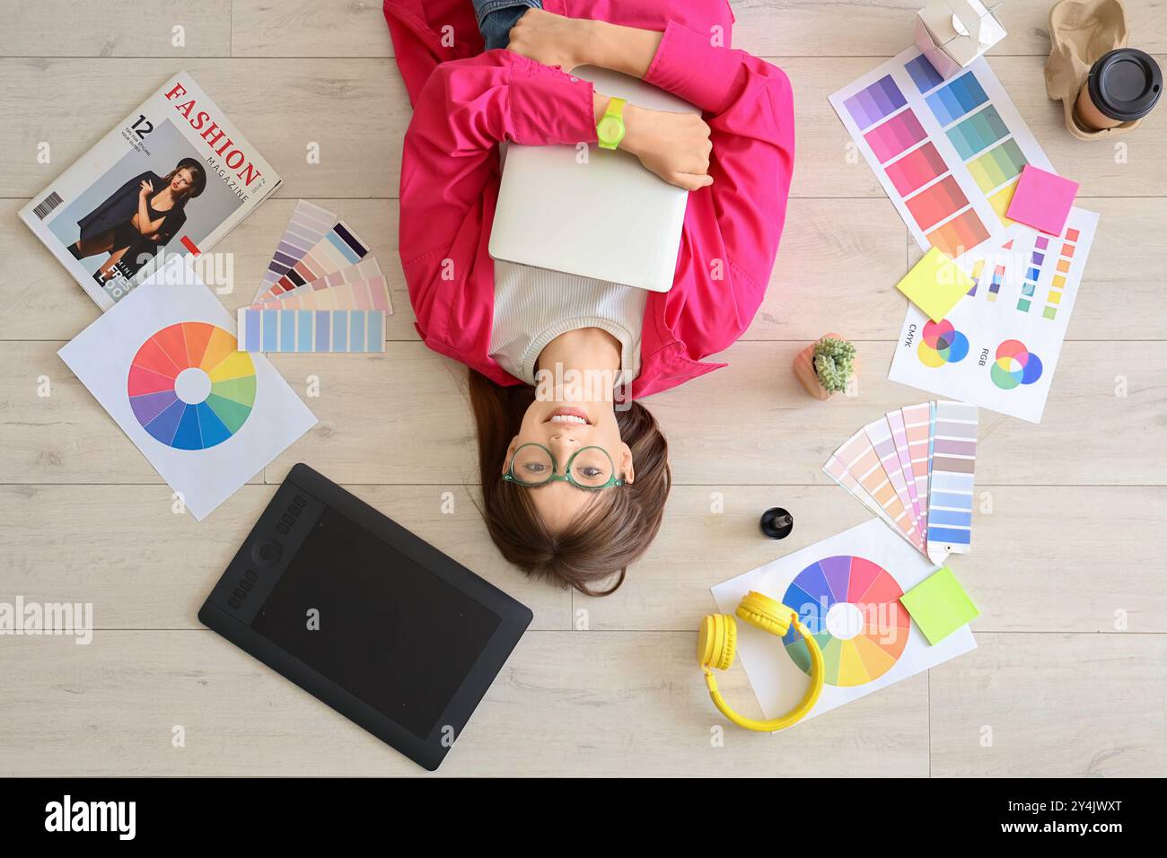 Female graphic designer with laptop, tablet and color palettes lying on ...