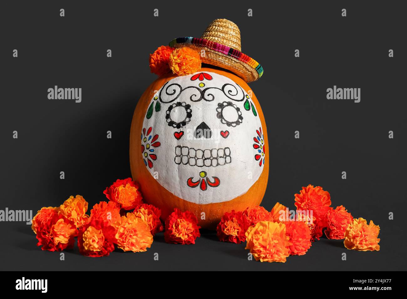 Pumpkin with painted skull, mini sombrero and beautiful marigolds on ...