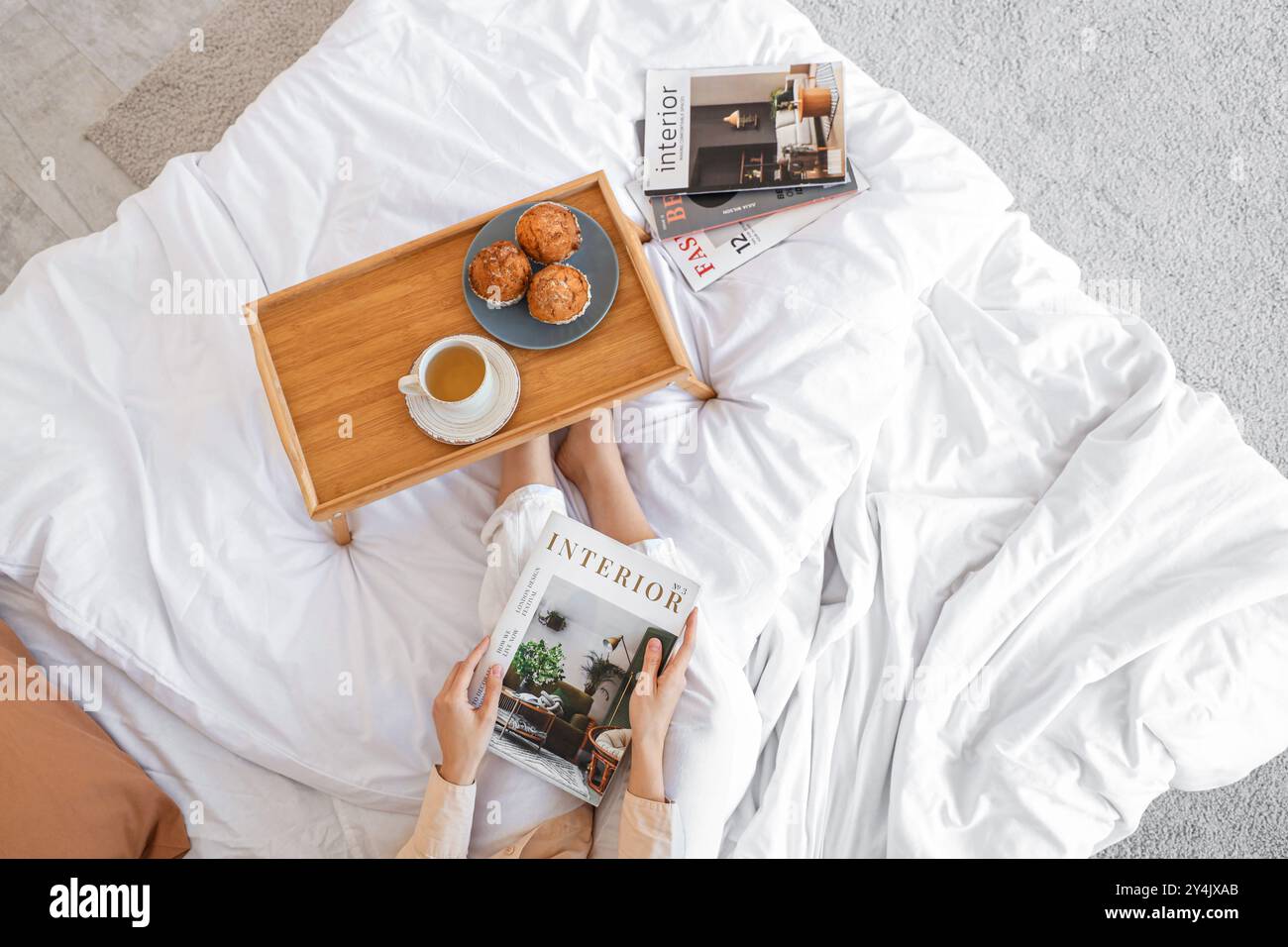 Young woman with magazines and breakfast on bed, top view Stock Photo ...