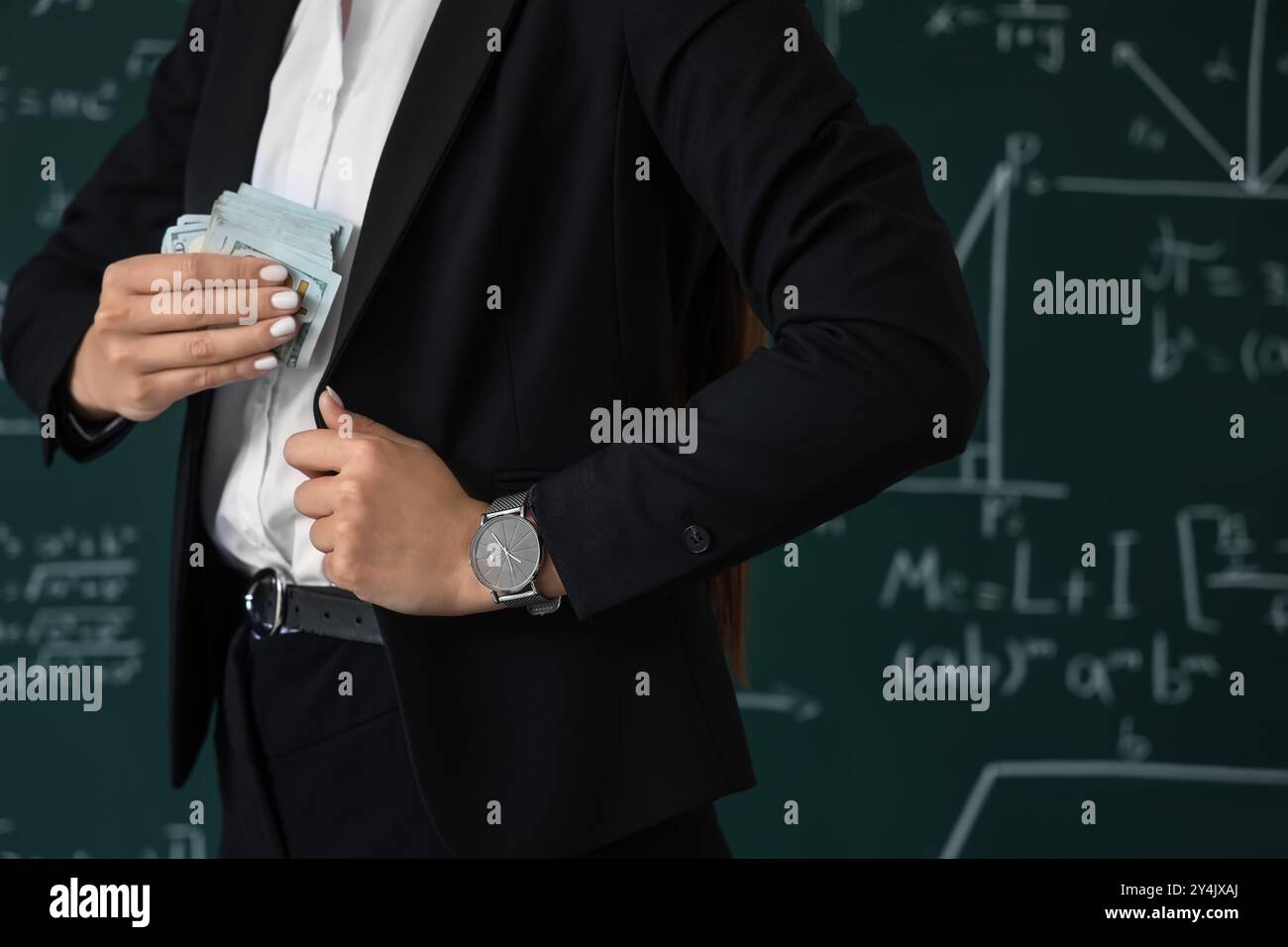 Female teacher with bribe in classroom, closeup. Corruption concept ...