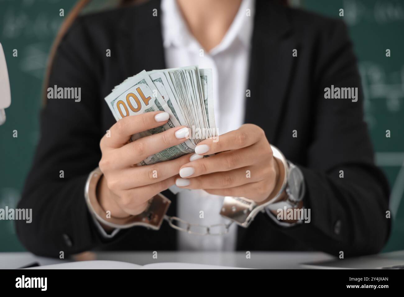 Female teacher with bribe in classroom, closeup. Corruption concept ...