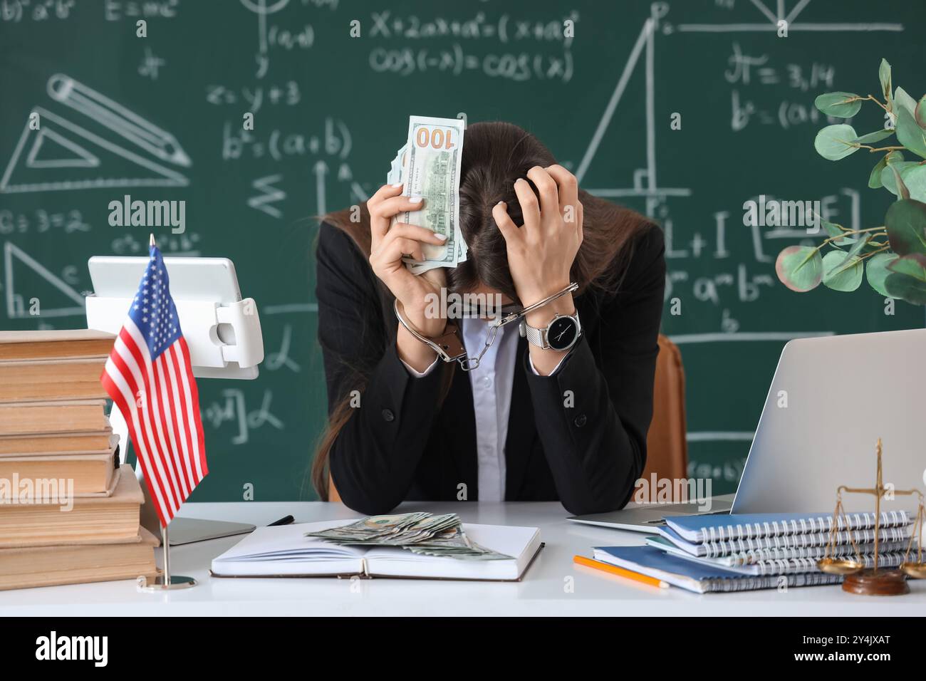 Handcuffed female teacher with bribe at table in classroom. Corruption ...