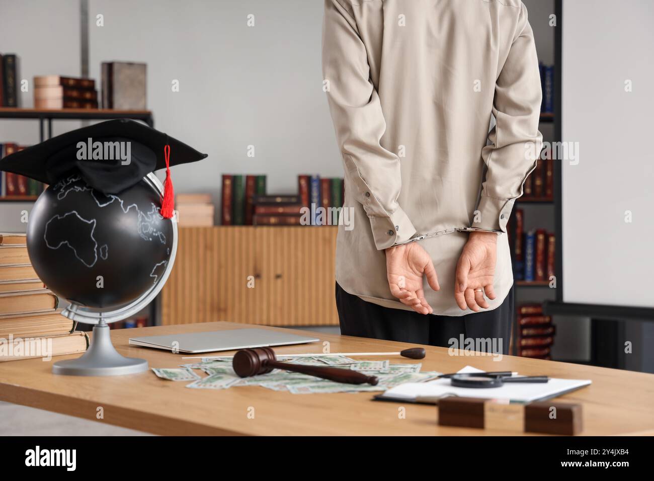 Handcuffed male teacher in classroom, back view. Corruption concept ...