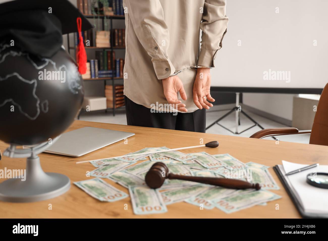 Handcuffed male teacher in classroom, back view. Corruption concept ...