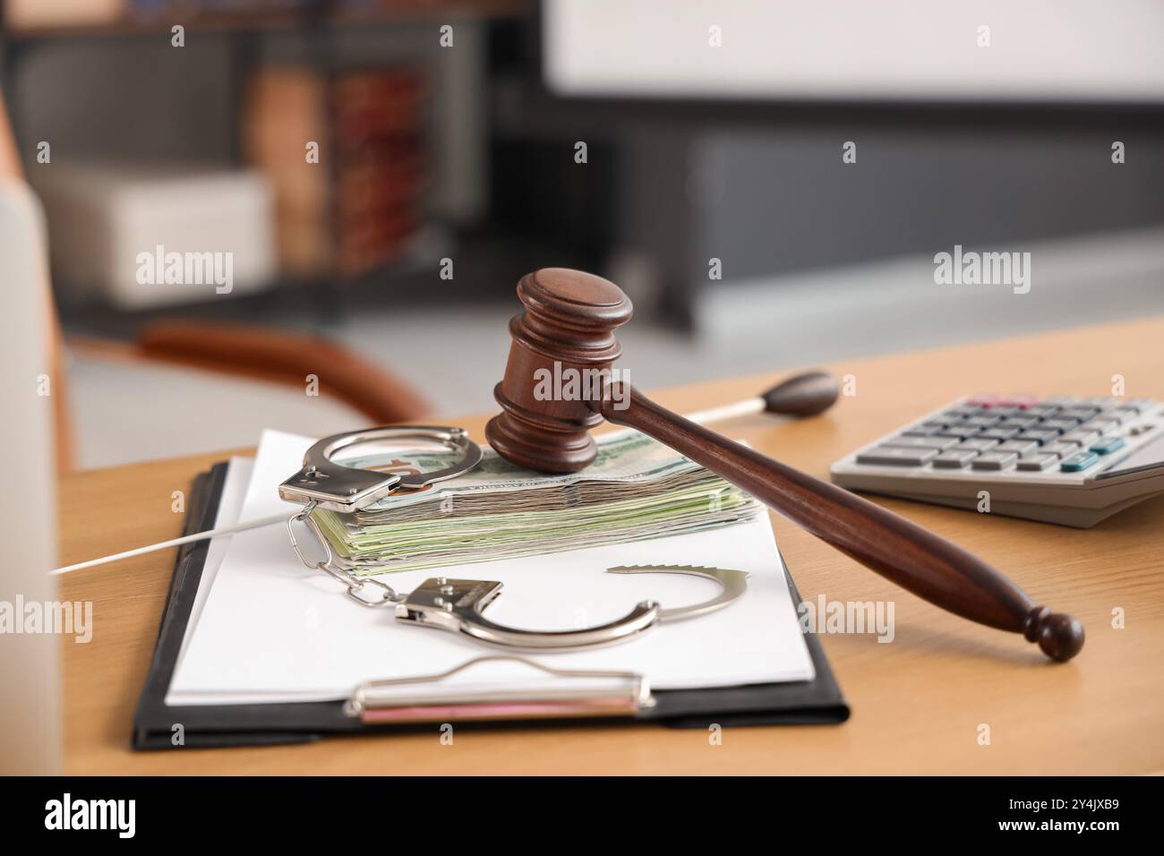 Judge's gavel with handcuffs, money and clipboard on teacher's table in ...