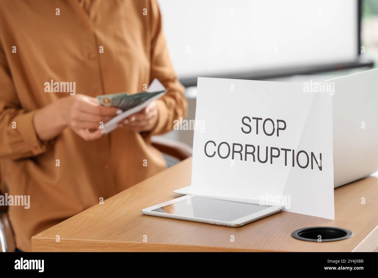 Paper with text STOP CORRUPTION on teacher's table in classroom ...