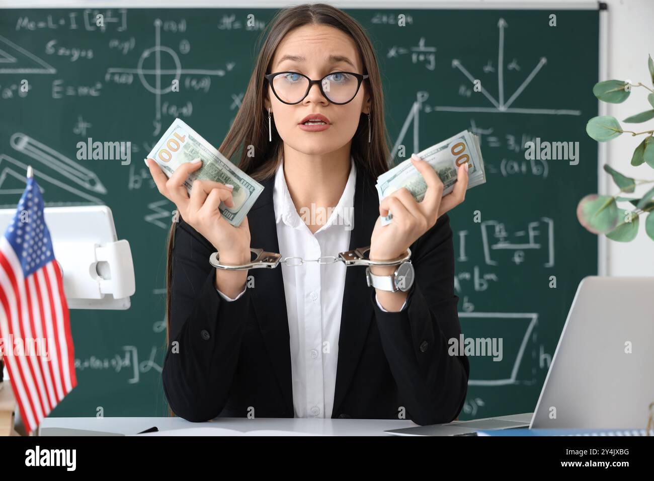 Handcuffed female teacher with bribe in classroom. Corruption concept Stock Photo - Alamy