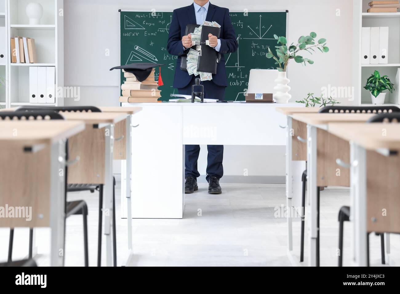 Handcuffed male teacher with briefcase and bribe in classroom ...