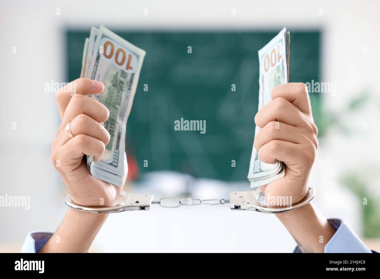 Handcuffed male teacher with bribe in classroom, closeup. Corruption ...