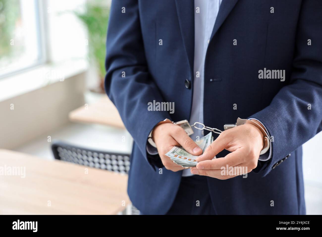Handcuffed male teacher with bribe in classroom, closeup. Corruption ...