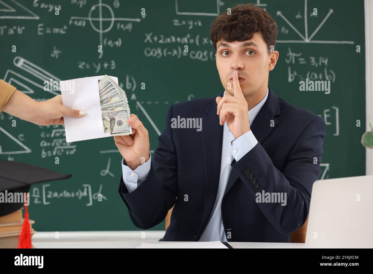 Male teacher showing silence gesture and taking bribe in classroom ...