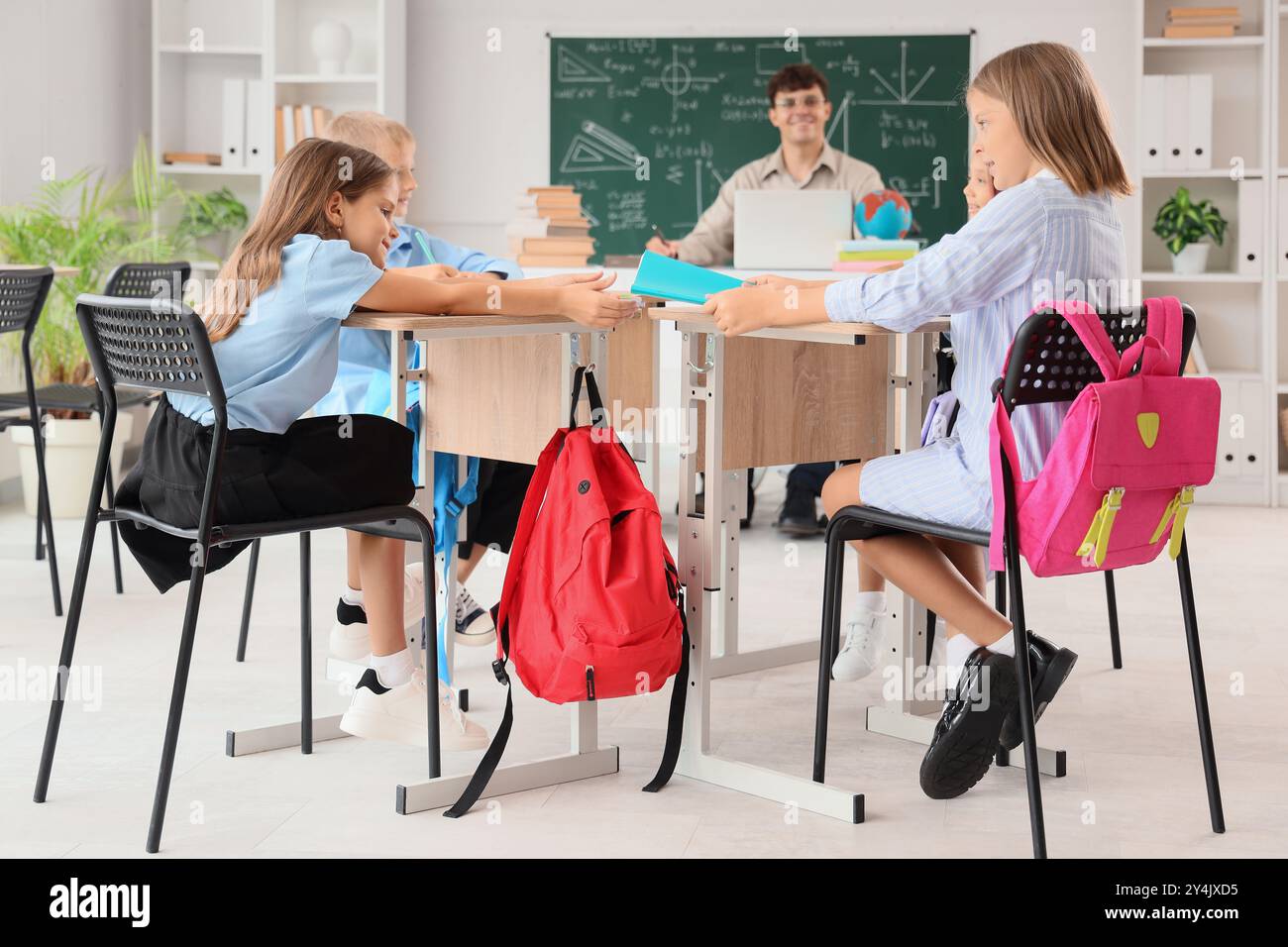 Little schoolgirls having lesson in classroom Stock Photo - Alamy