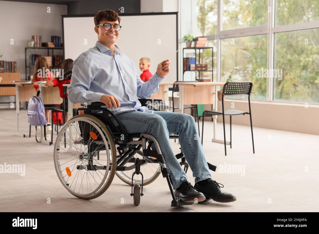 Male teacher in wheelchair with pointer at school Stock Photo - Alamy