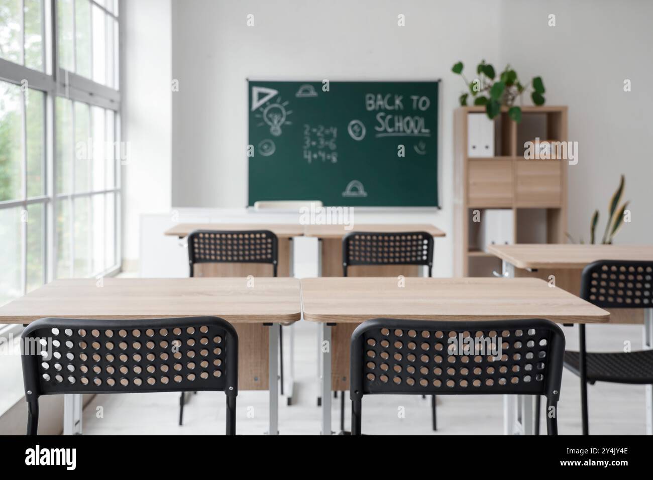 Interior of empty classroom with school desks and text BACK TO SCHOOL ...