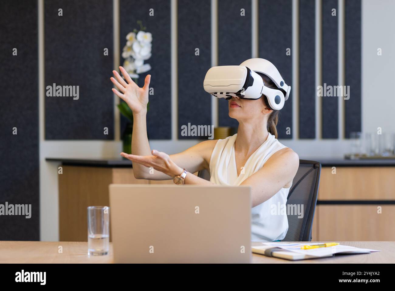 Using VR headset, businesswoman interacting with virtual environment at ...