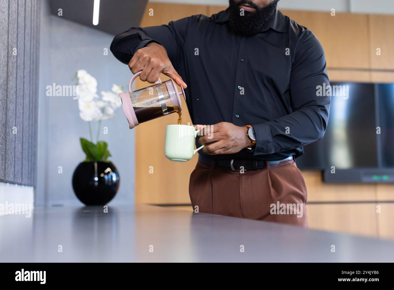 Pouring coffee from French press into mug, man preparing drink in ...