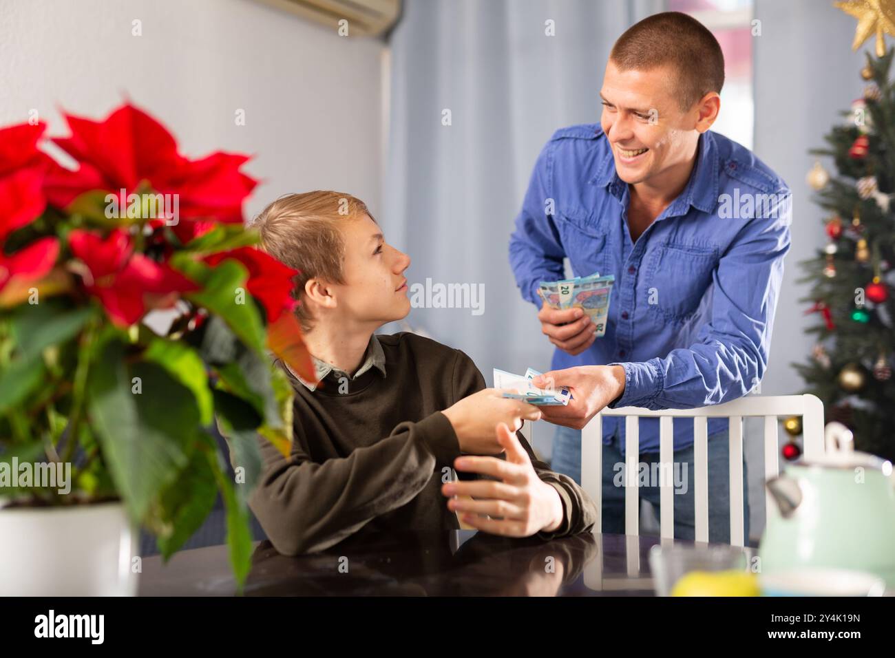 Father gives pocket money to his son to celebrate christmas Stock Photo ...