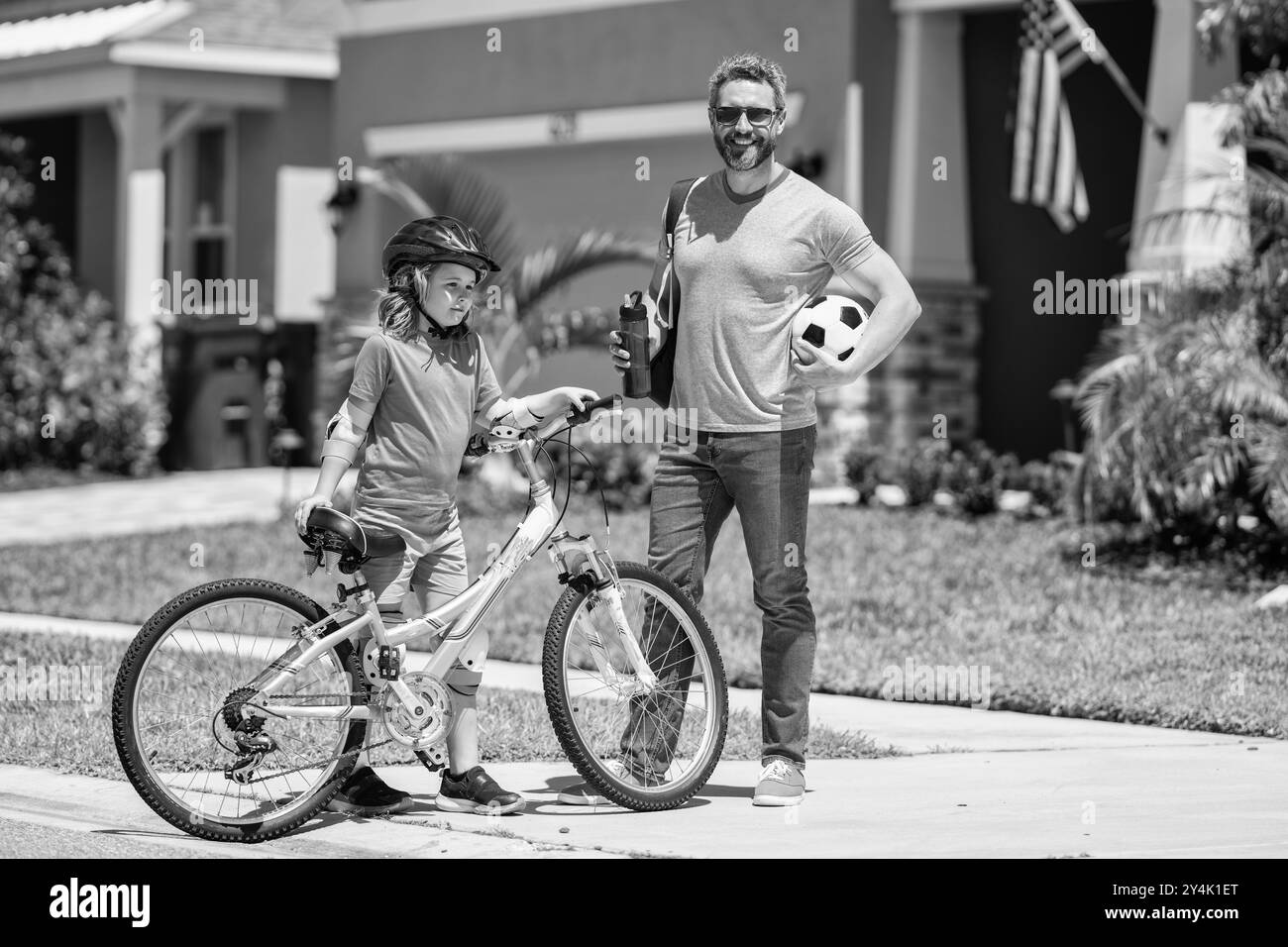 dad and son enjoying a ride together. Supportive father guiding son ...