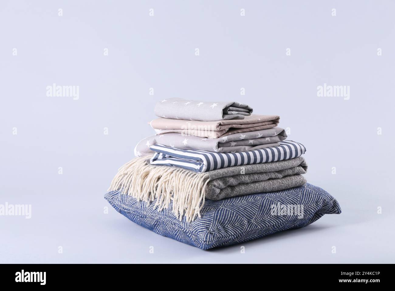 Stack of clean bed sheets and pillow on white background Stock Photo ...