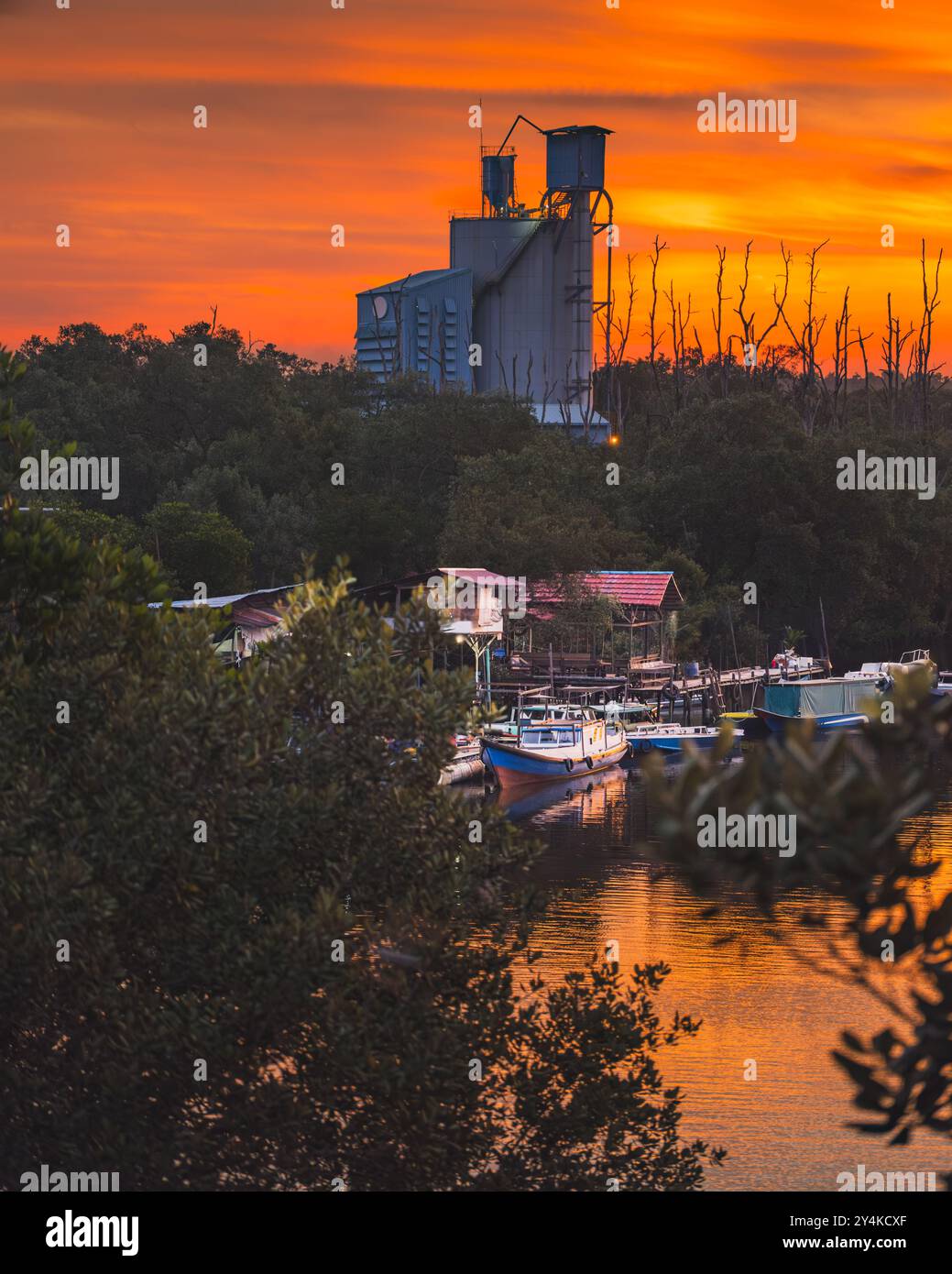 A breathtaking sunset illuminates the sky above a picturesque riverside ...