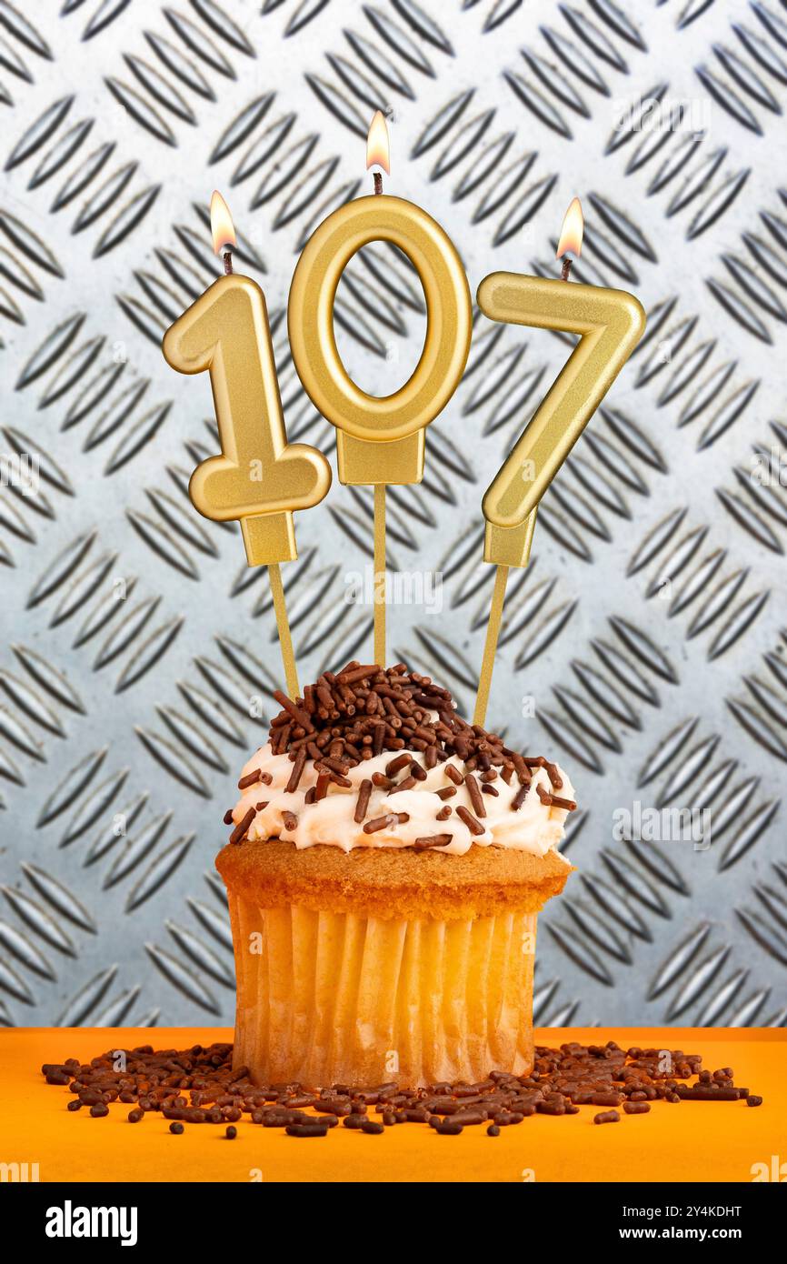 Chocolate cupcake with candle number 107 - Birthday on industrial ...