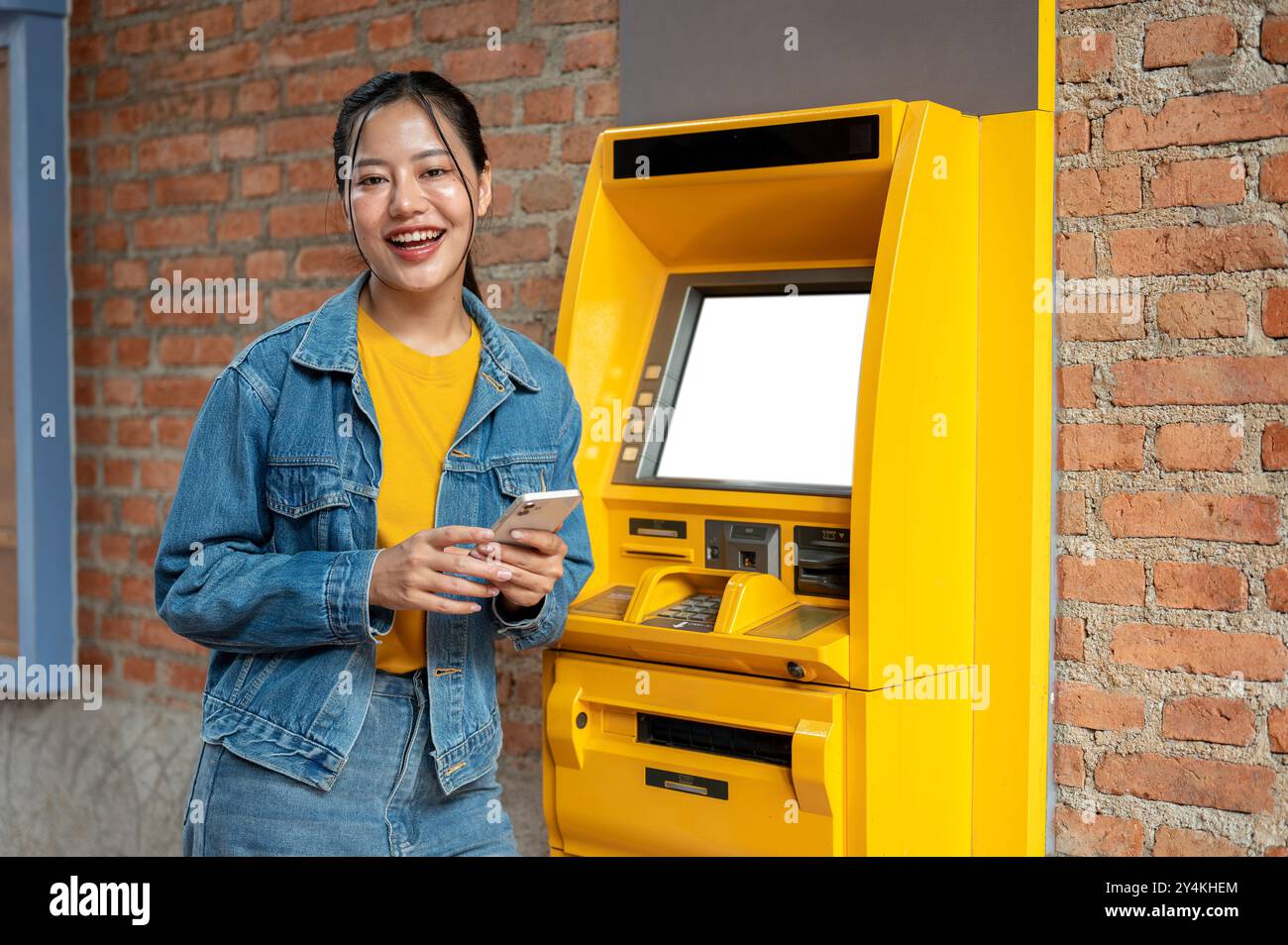 A beautiful Asian woman in a denim jacket is standing in front of an ...