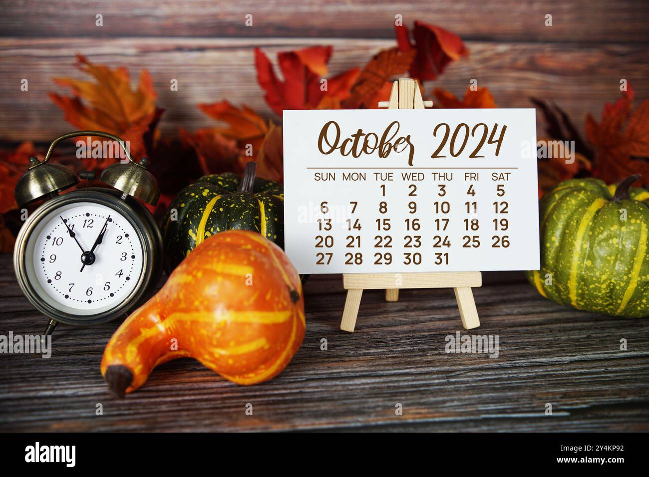 October 2024 monthly calendar with maple leaf on wooden background ...