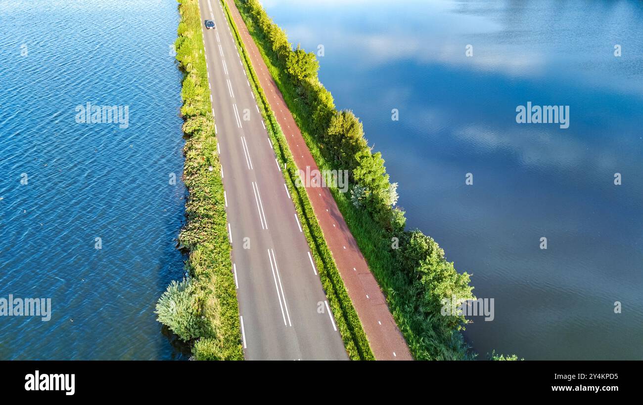 Aerial drone view of motorway road and cycling path on polder dam, cars ...