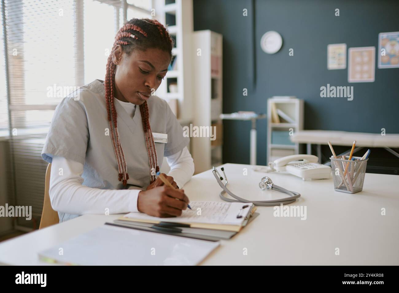 African American Nurse Reviewing Patient Records in Office Stock Photo ...