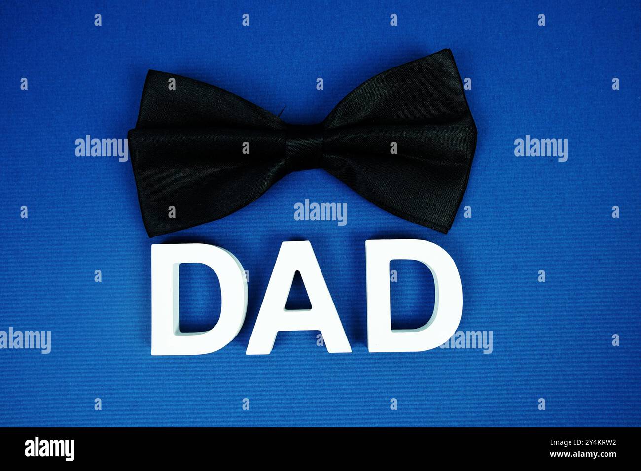 DAD alphabet letters with bow tie on navy blue background Stock Photo ...